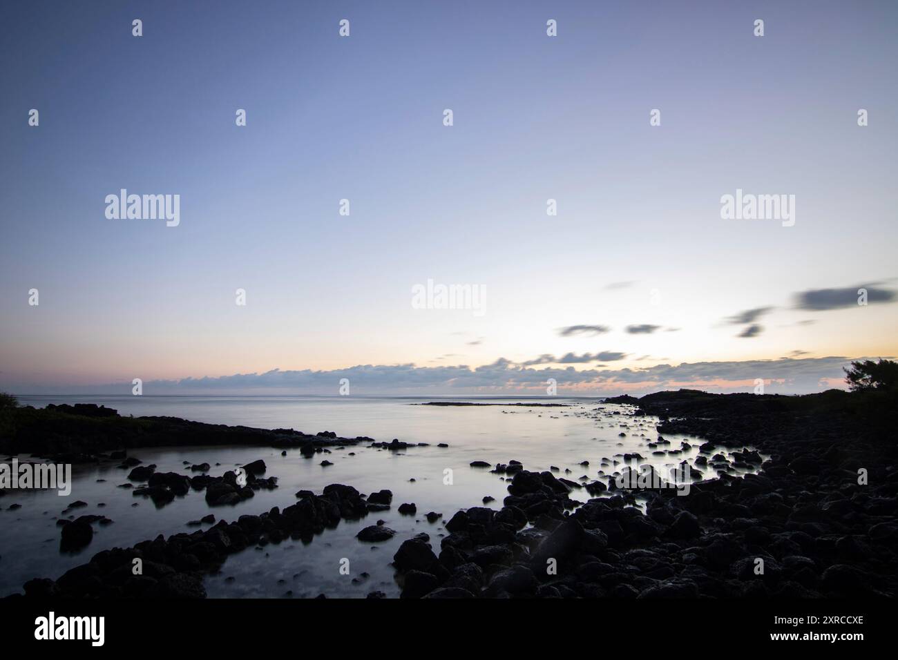 Small waves surround lava rocks by the sea, coastline of an island in ...