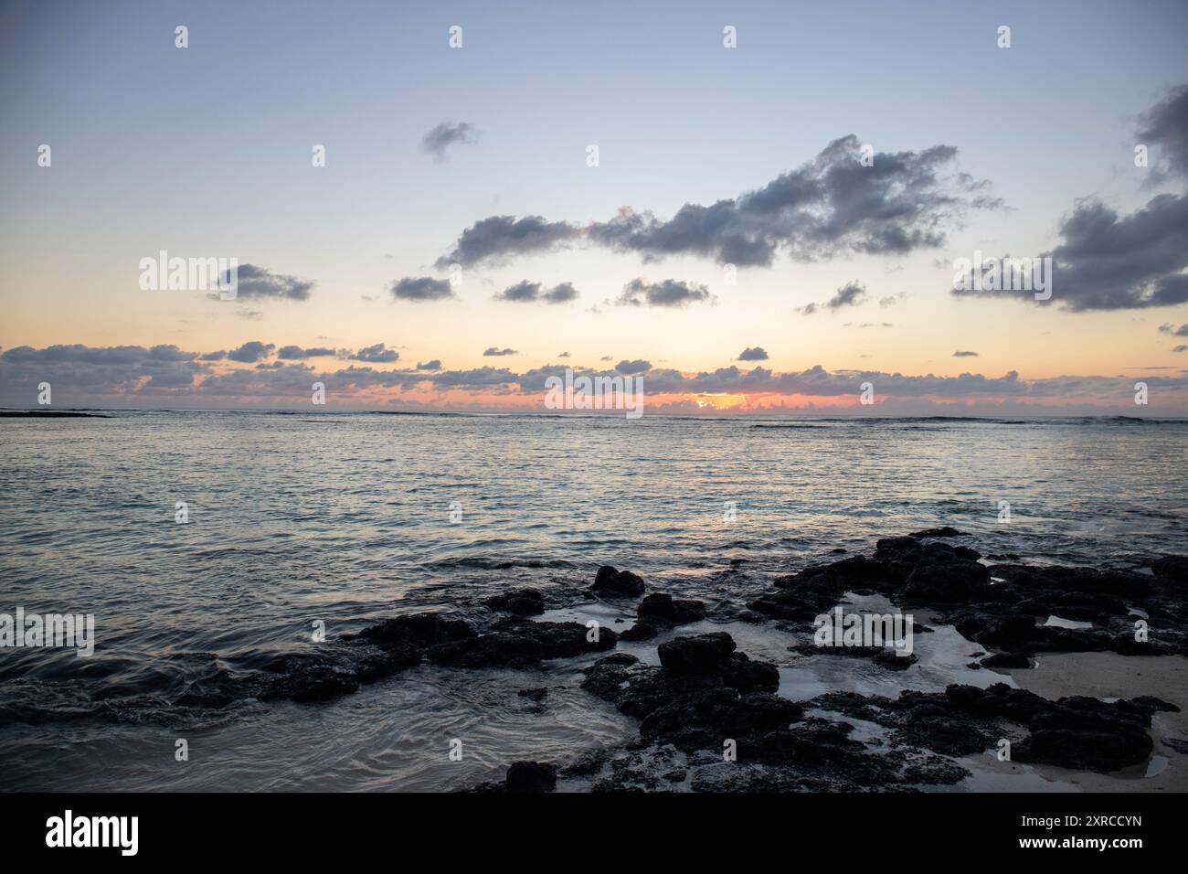 Small waves surround lava rocks by the sea, coastline of an island in ...