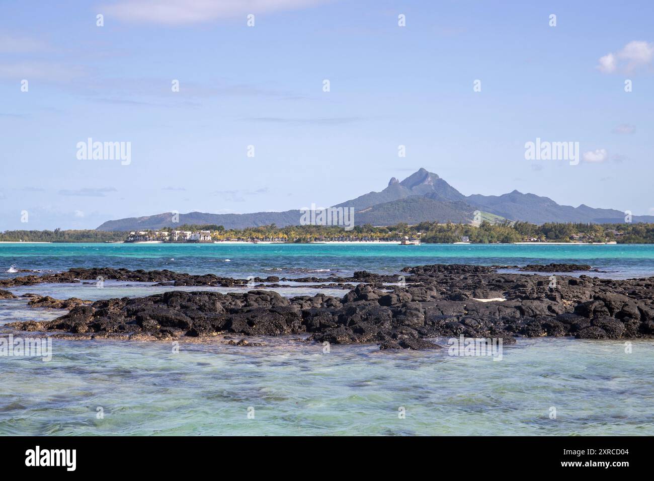 Small waves surround lava rocks by the sea, coastline of an island in ...