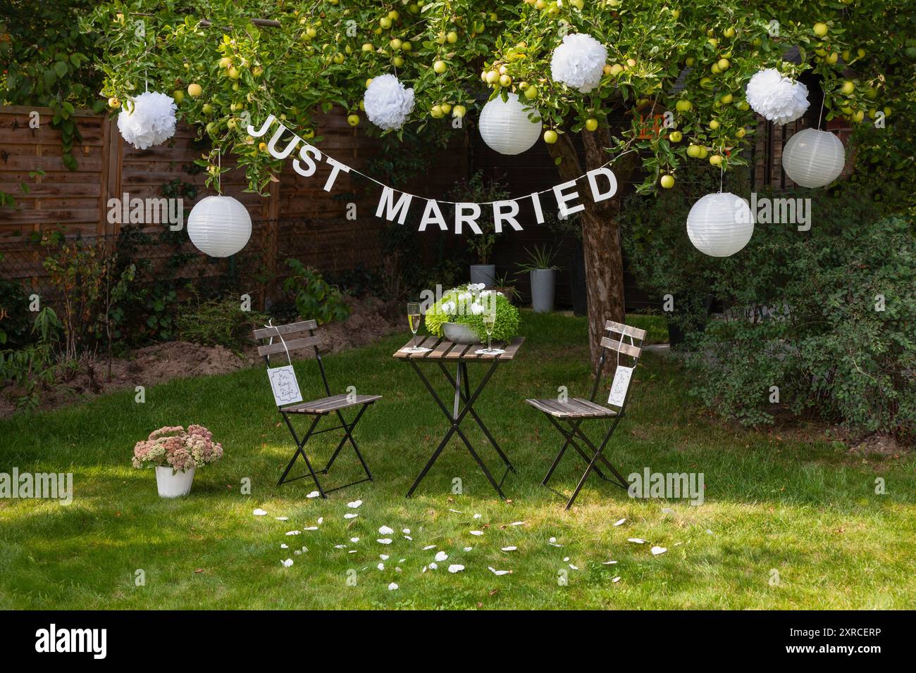 A garland with wise letters and the inscription Just Married hangs on ...