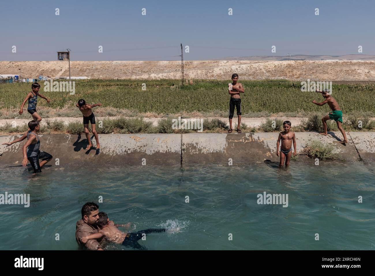 Sahl Ar Ruj, Syria. 09th Aug, 2024. Syrian youngsters swim in a water ...