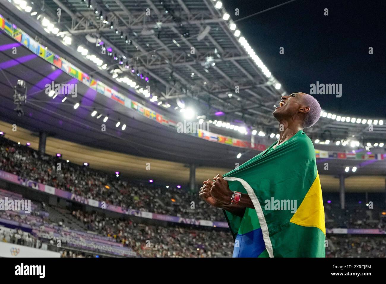 Alison Dos Santos, of Brazil, celebrates after winning the bronze medal ...