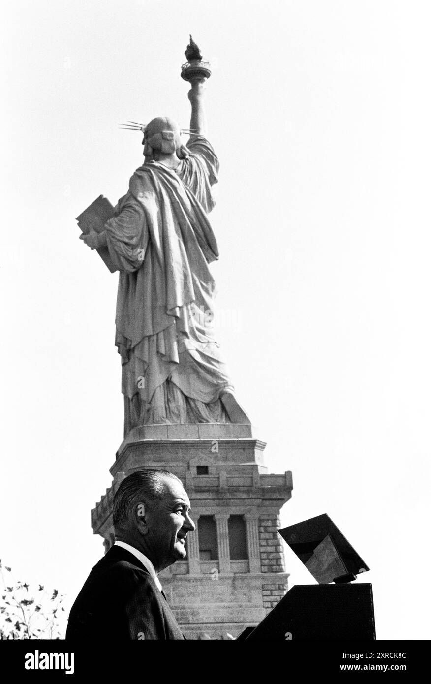 U.S. President Lyndon B. Johnson speaking at podium with Statue of ...