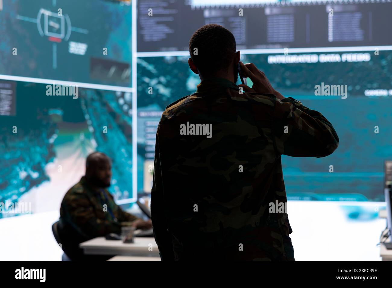 Military man answers phone call in a mission control center, working ...