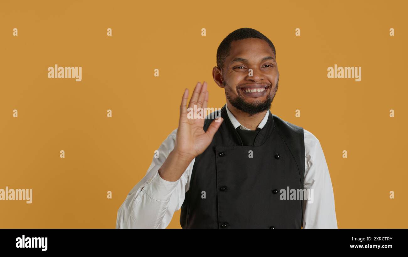 Skilled waiter waving and greeting clients at five star restaurant ...
