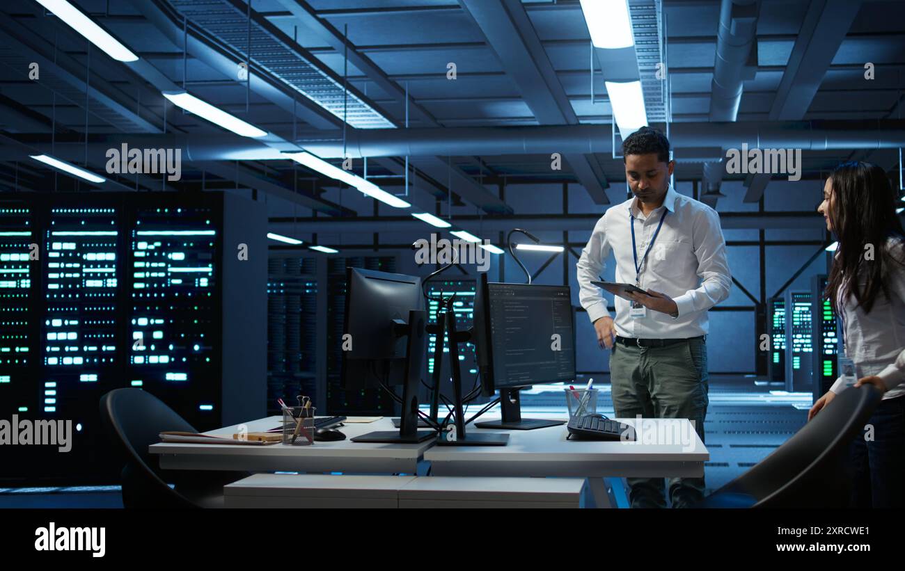 Admin in data center working with colleague to maintaining accurate ...
