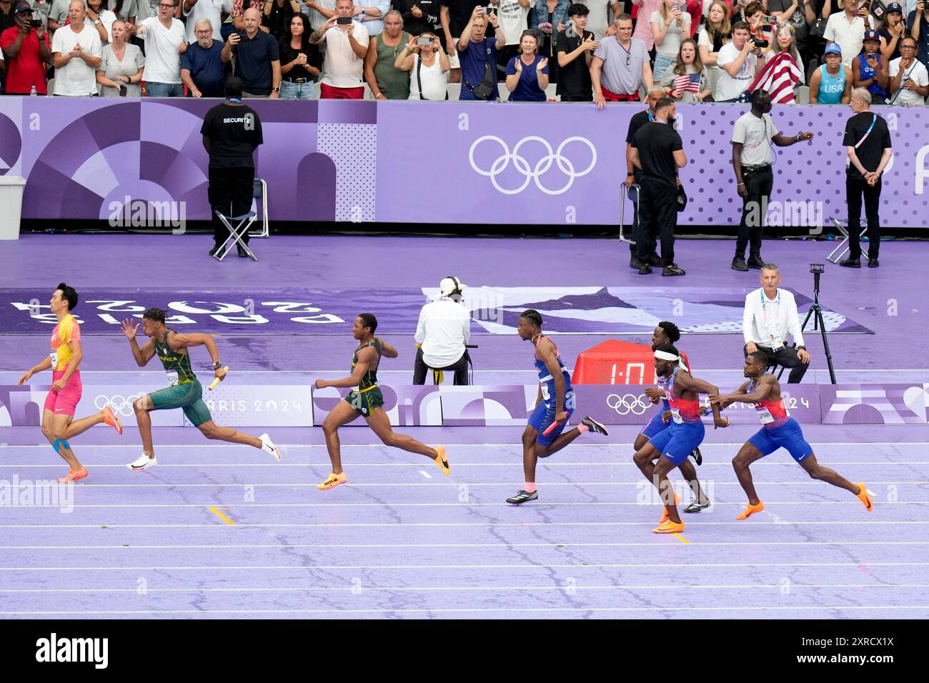 Christian Coleman, right, of the United States, struggles to hand the ...