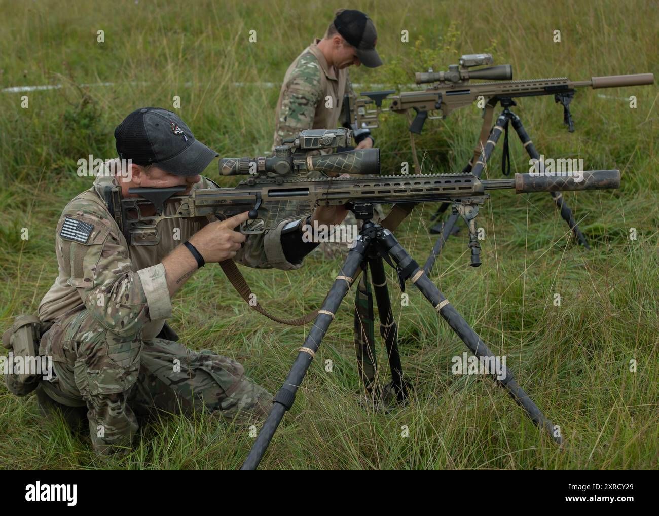 A U.S. Army sniper team, assigned to the 10th Mountain Division, mount ...