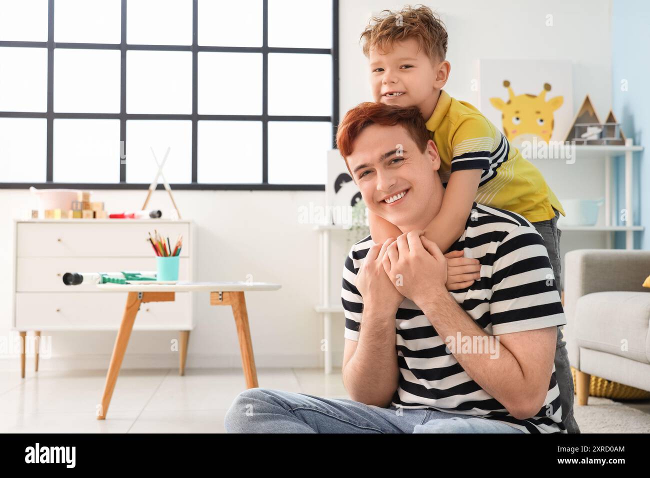 Little boy hugging his father at home Stock Photo - Alamy