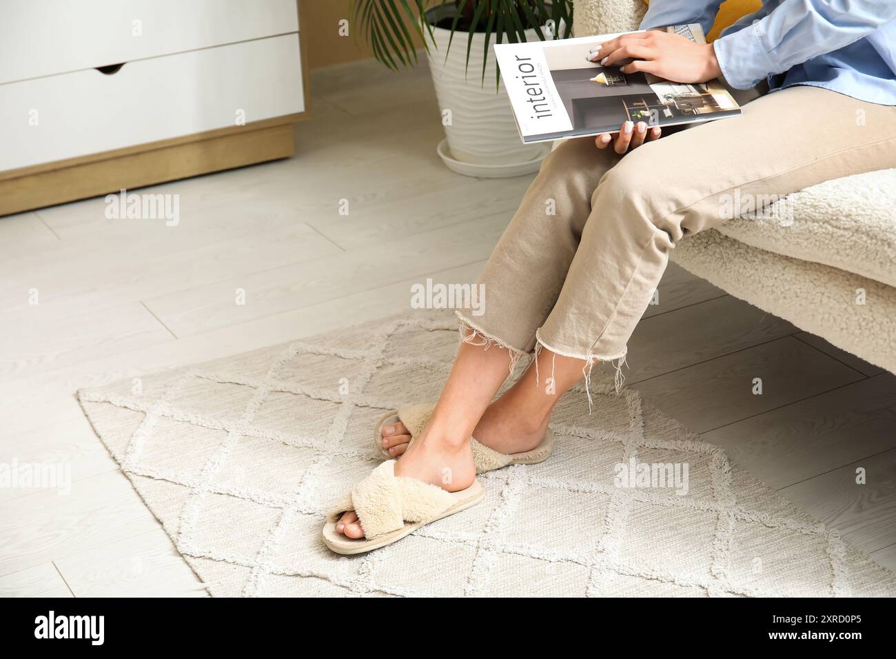 Young woman in slippers reading magazine at home Stock Photo - Alamy