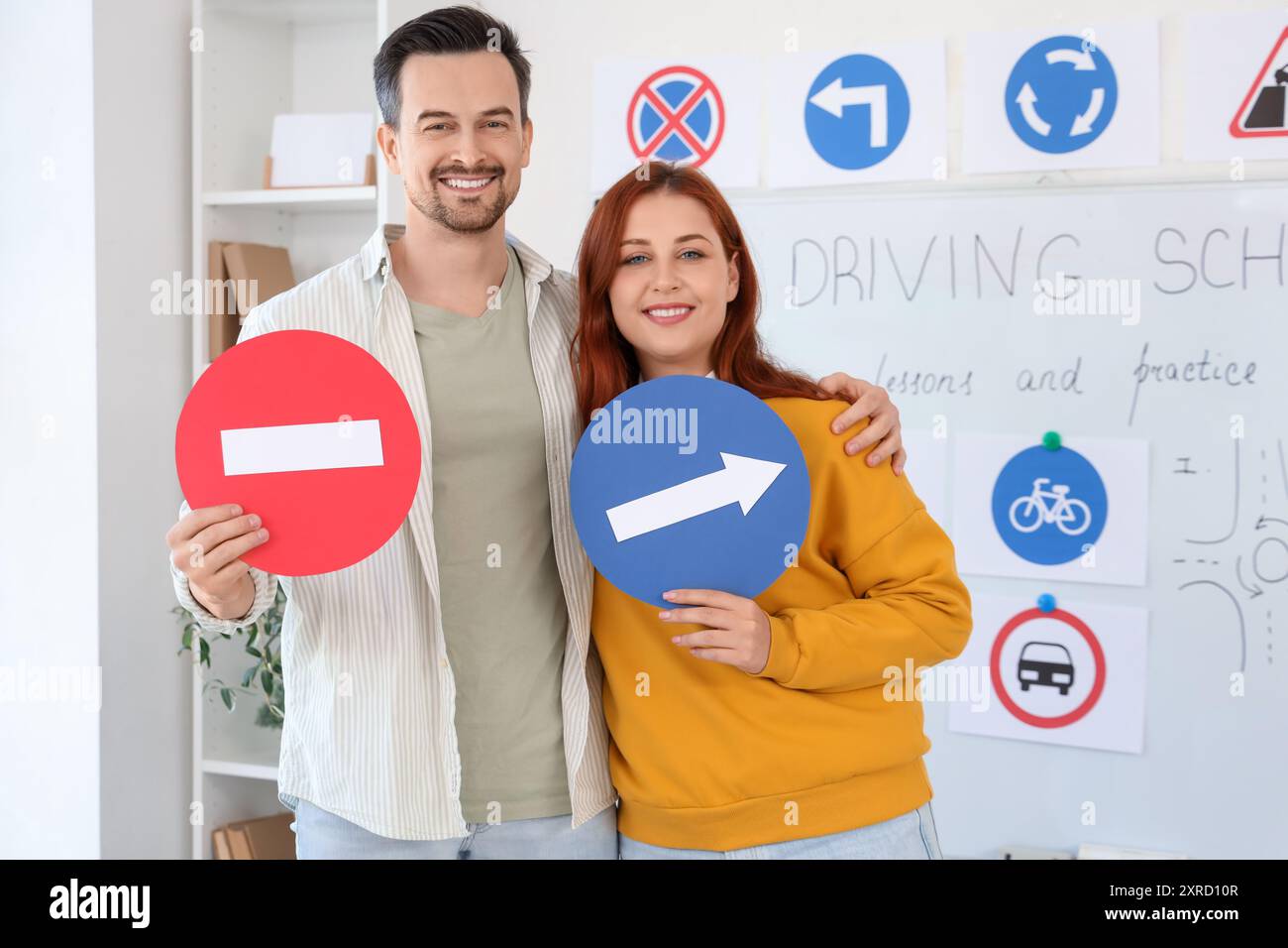 People with road signs hugging at driving school Stock Photo - Alamy