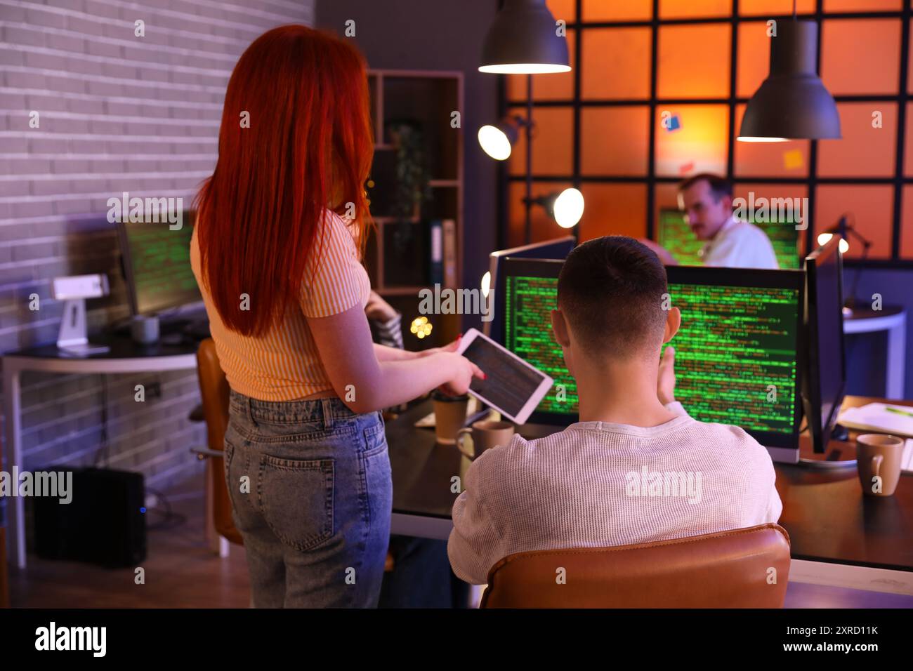 Young programmers working in office at night, back view Stock Photo - Alamy