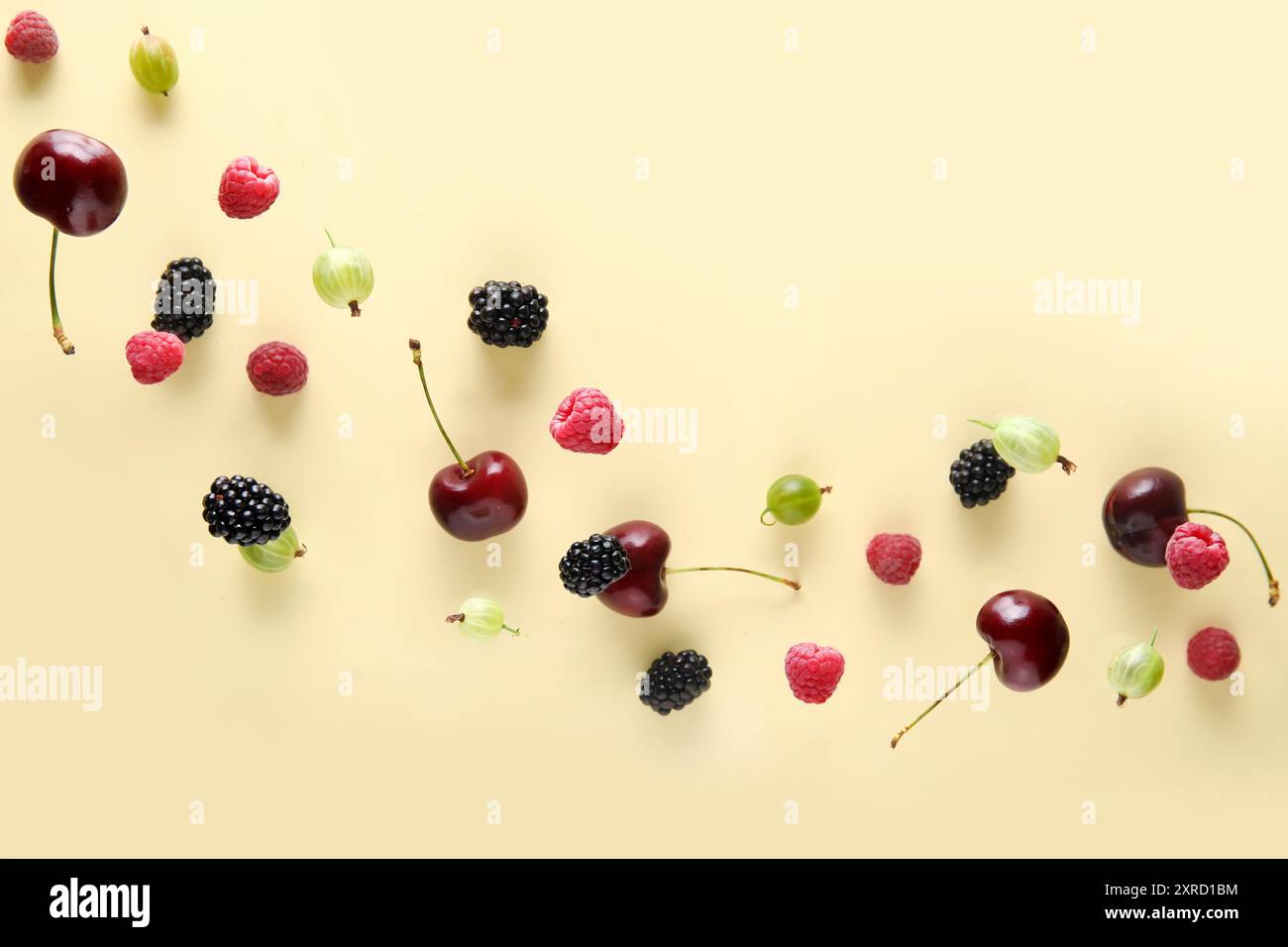 Different berries flying on beige background Stock Photo - Alamy