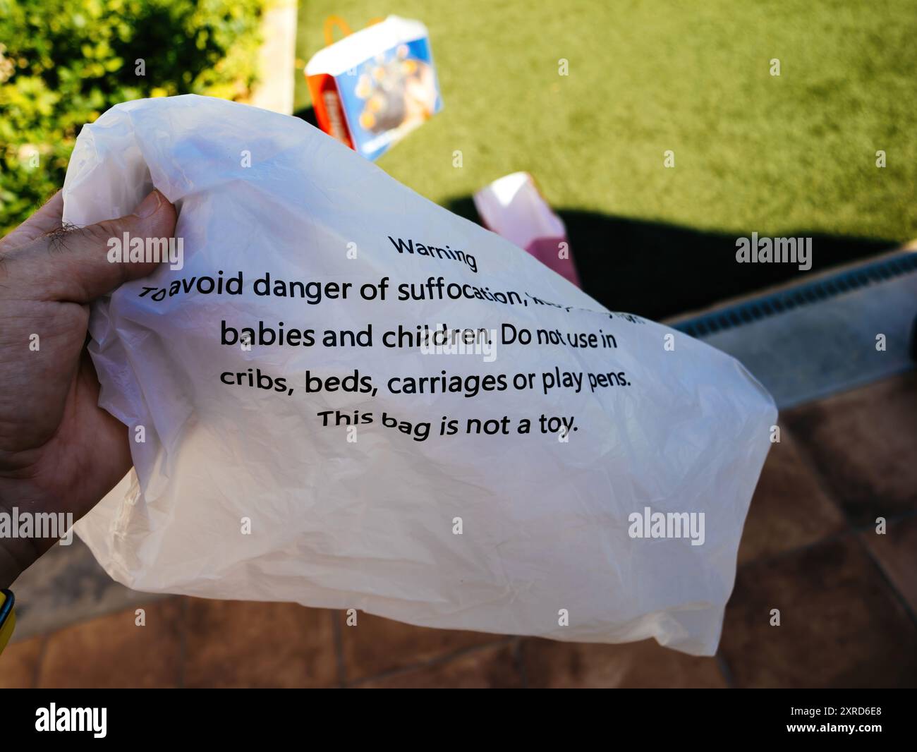 Inca, Spain - Jul 11, 2024: A male hand holds a plastic bag with a ...