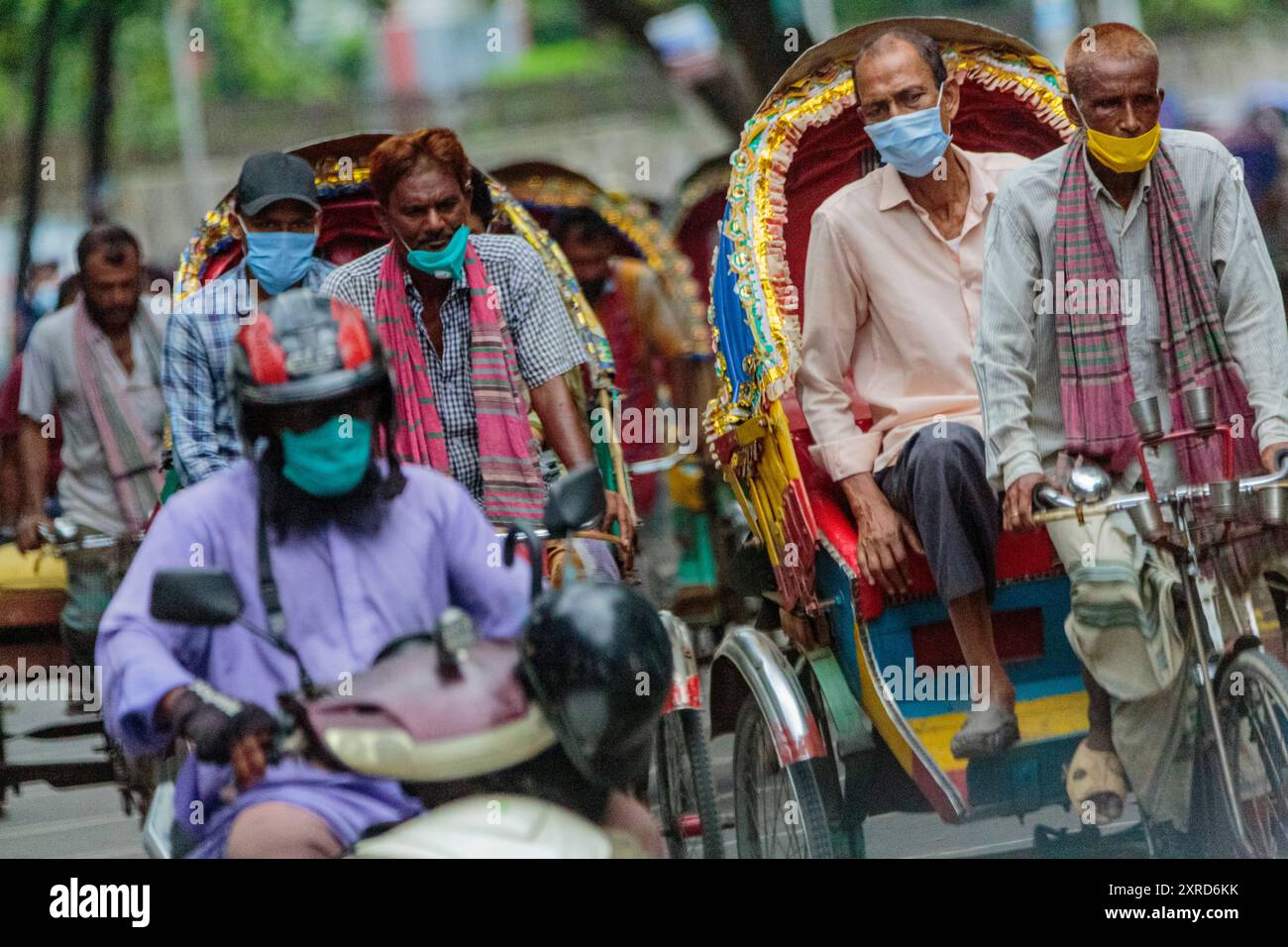 Ricksha-walas, or rickshaw drivers with their passengers on the streets ...