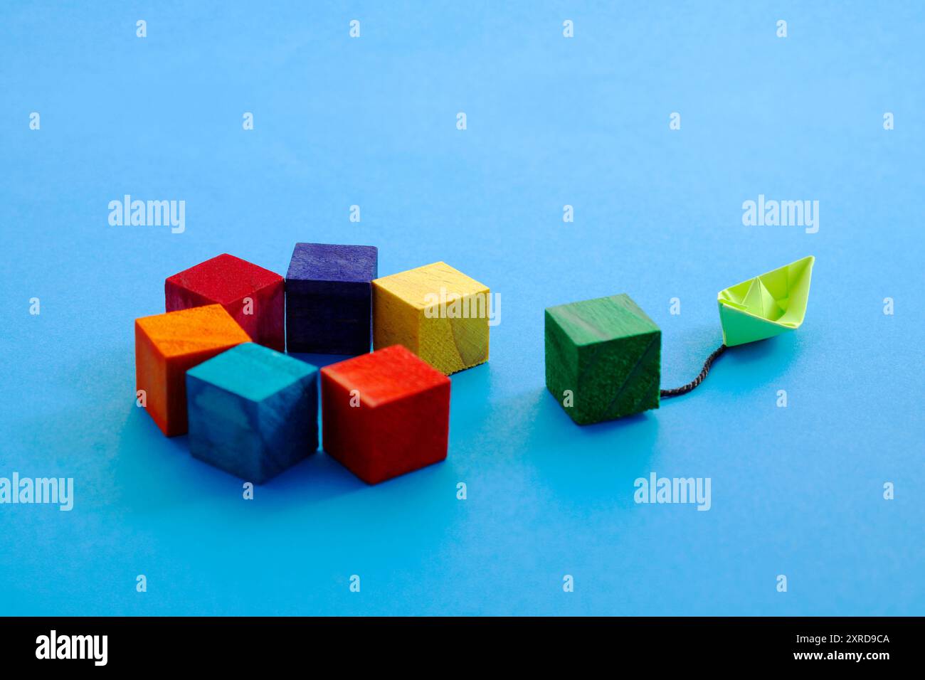 Boat pulling out and moving wooden cube from a group Stock Photo - Alamy