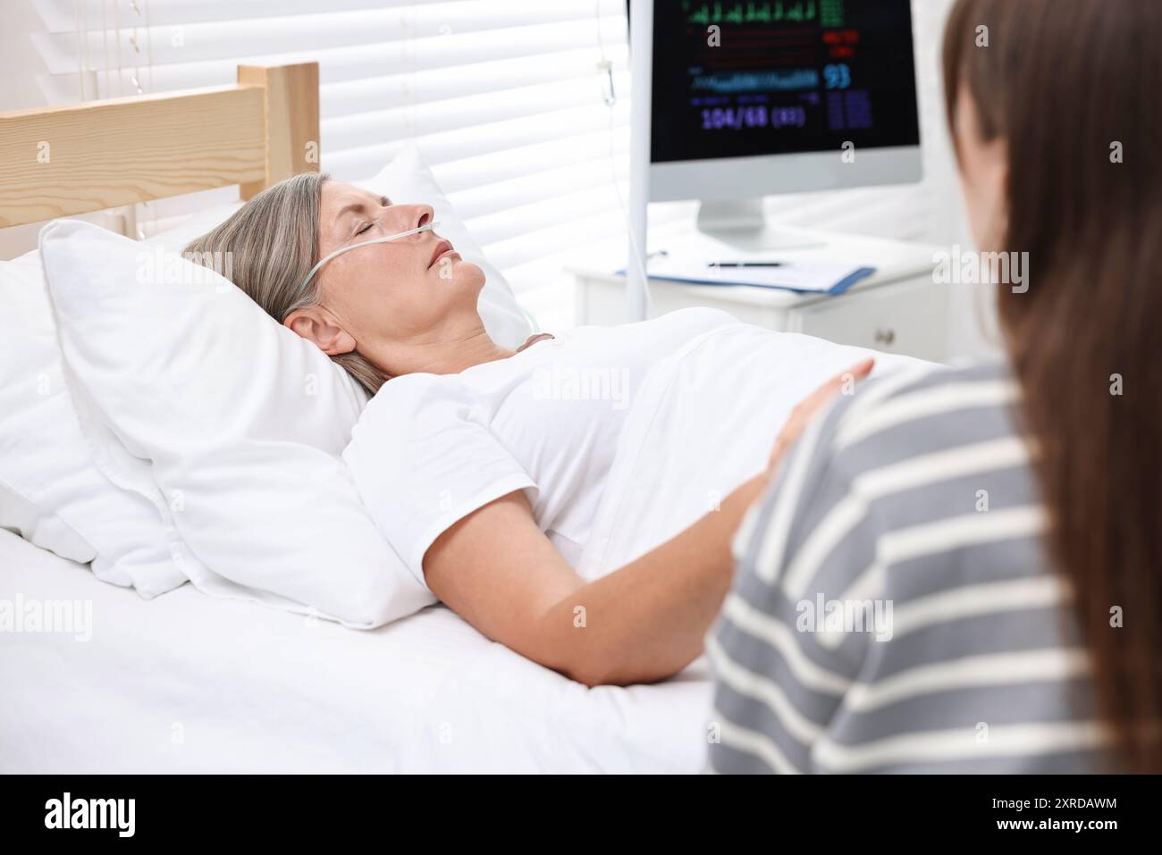 Coma patient. Woman near her unconscious mother in hospital Stock Photo ...