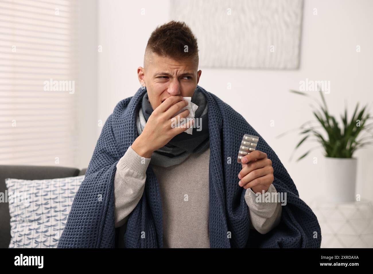 Cold symptom. Young man with runny nose at home Stock Photo - Alamy