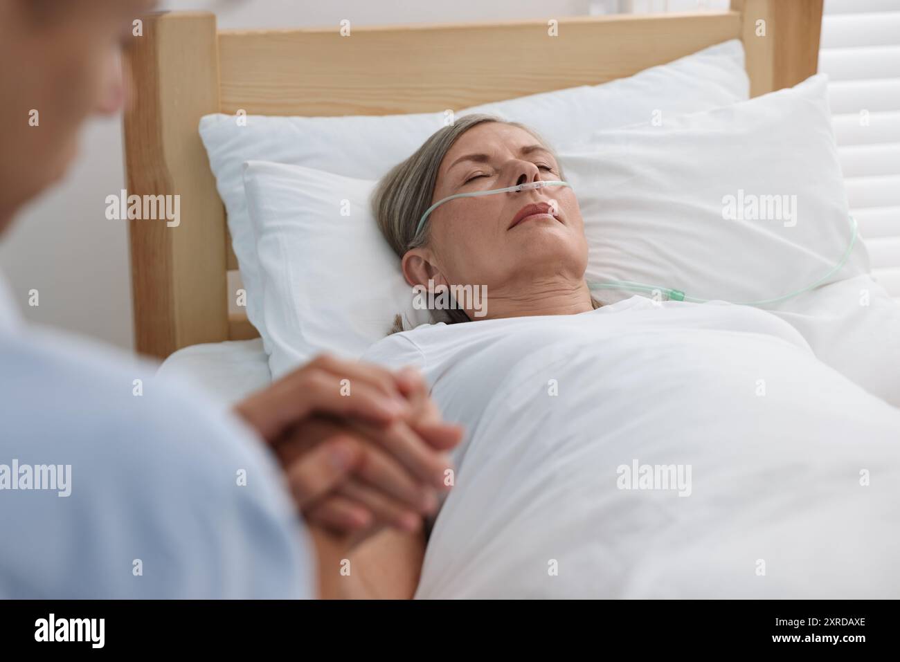 Coma patient. Man near his unconscious mother in hospital Stock Photo ...