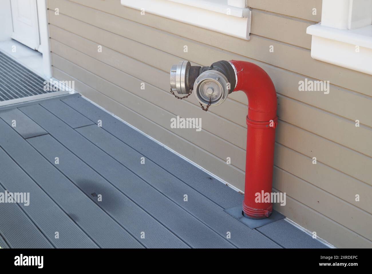 A Bright Red Fire Hydrant Attachment Installed on a Wooden Deck in an ...