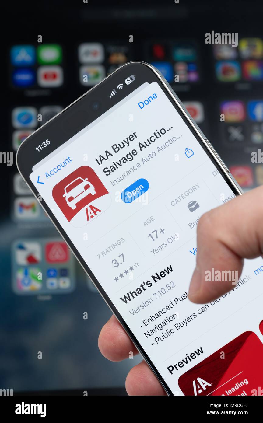 New York, USA - August 5, 2024: Smartphone in hand with IAA salvage auction app on screen macro ...