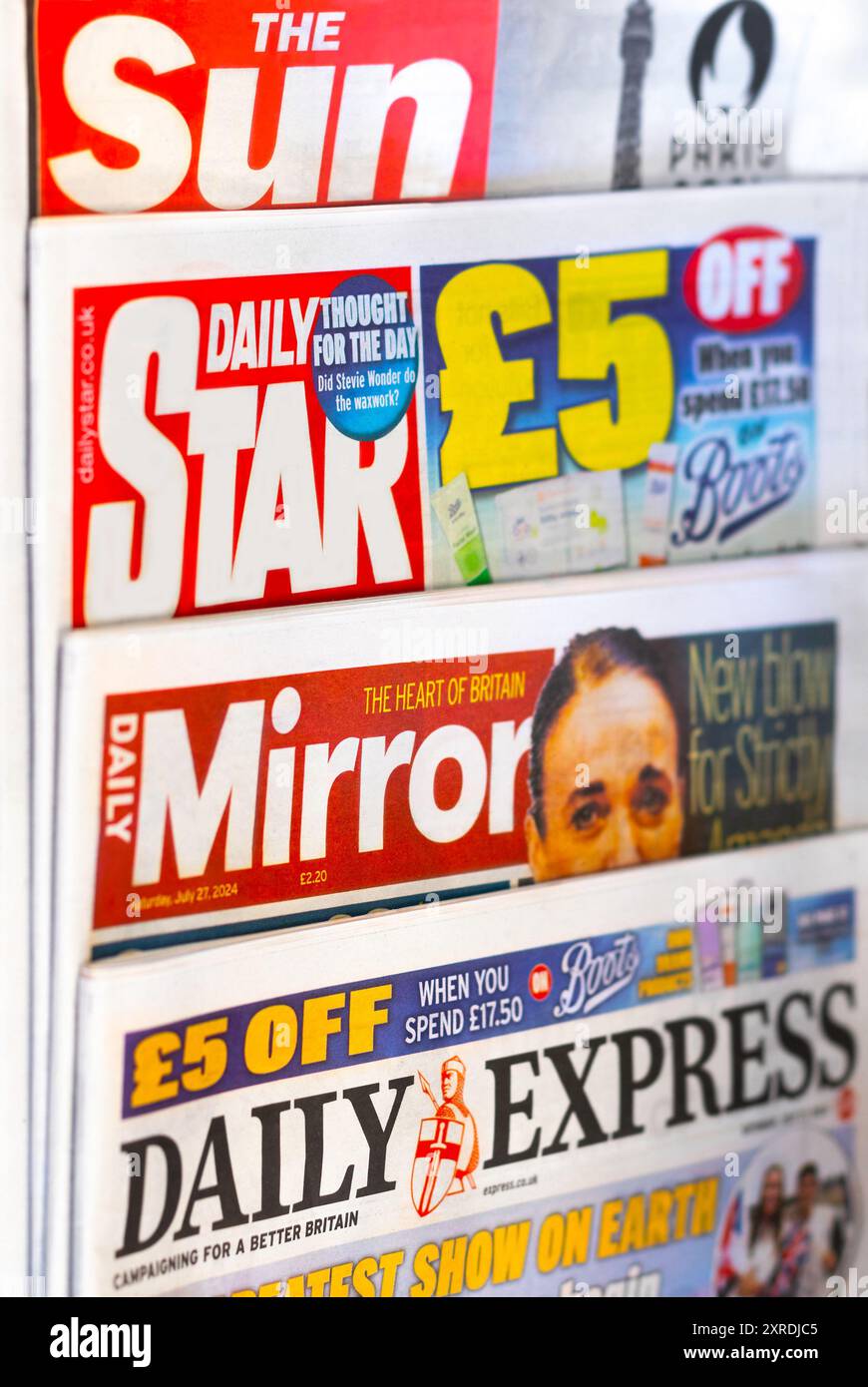 Newspaper rack holding several international British tabloid newspapers ...