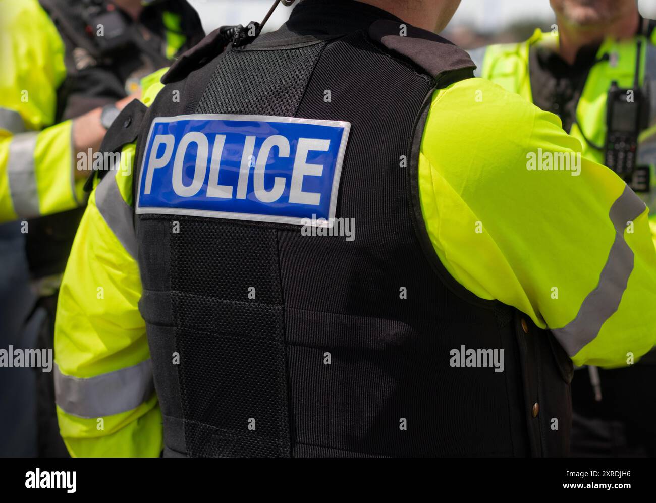 Close-up of 'POLICE' marking written on the back of a hi-visibility ...