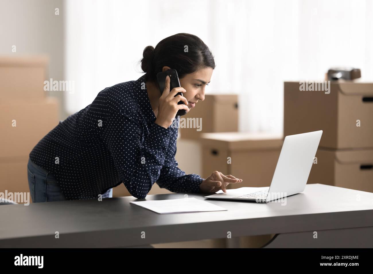 Woman make call, check orders working in warehouse use laptop Stock ...