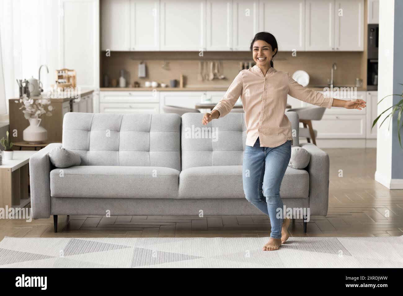 Happy young Indian woman dancing in living room Stock Photo - Alamy