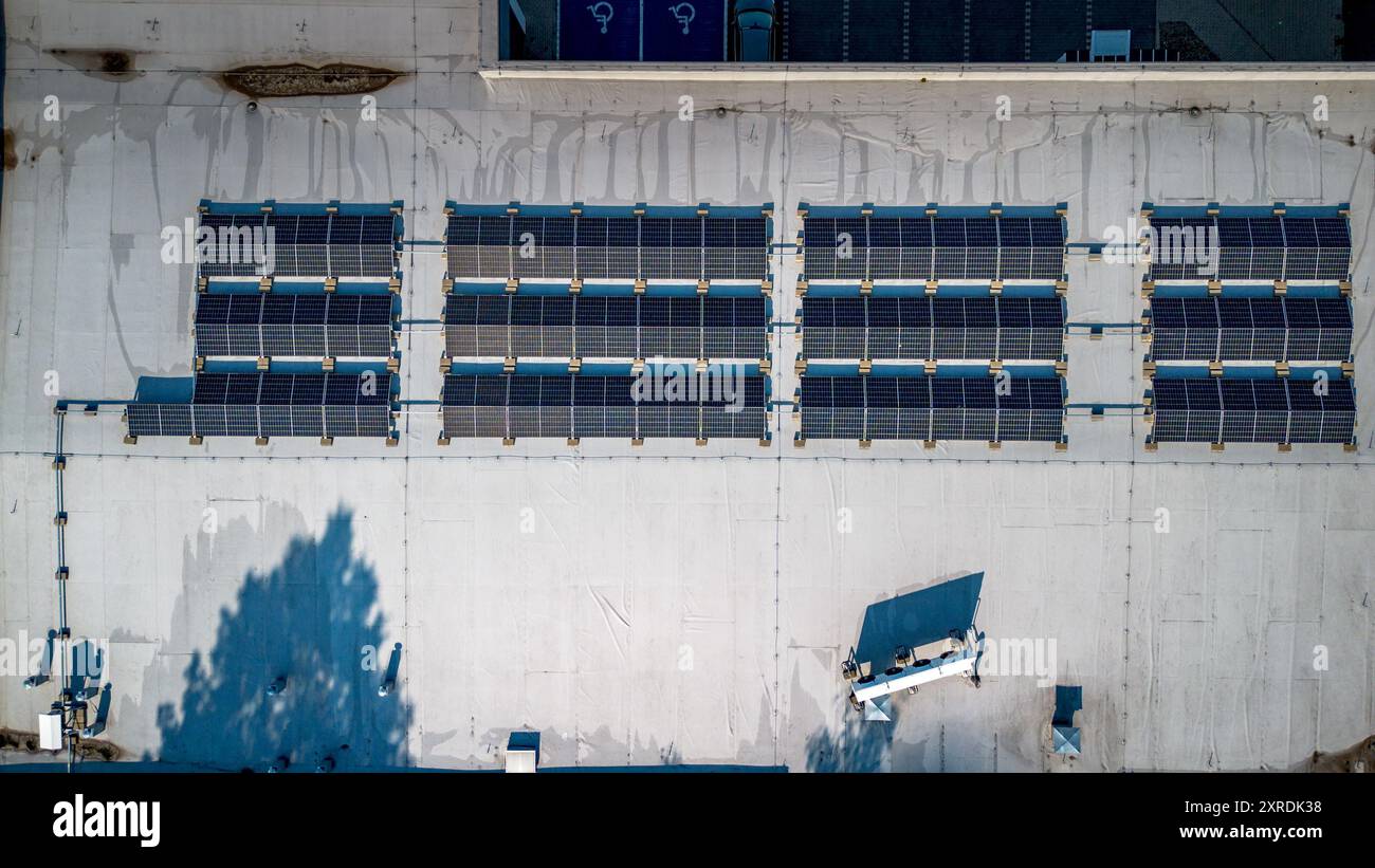 Solar panels installed on a commercial building rooftop during daylight ...