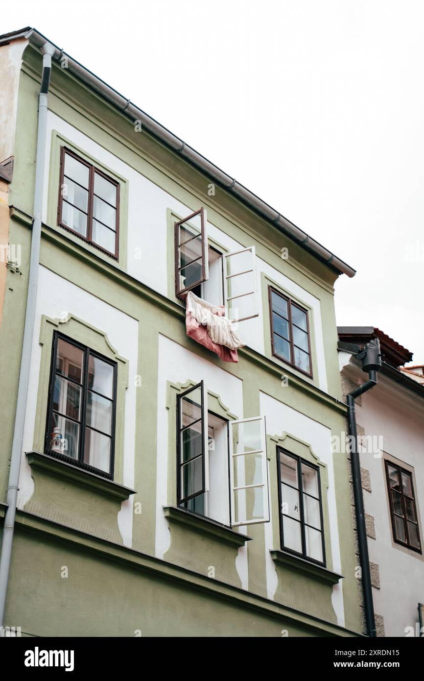A charming building features multiple open windows, showcasing a ...