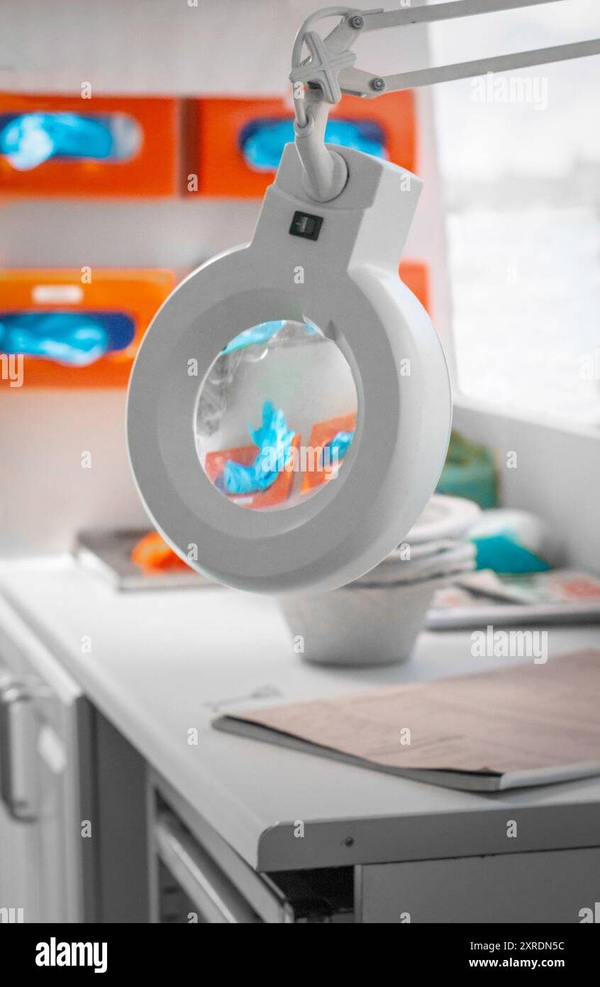 Examination laboratory setting featuring a magnifying lamp, disposable ...