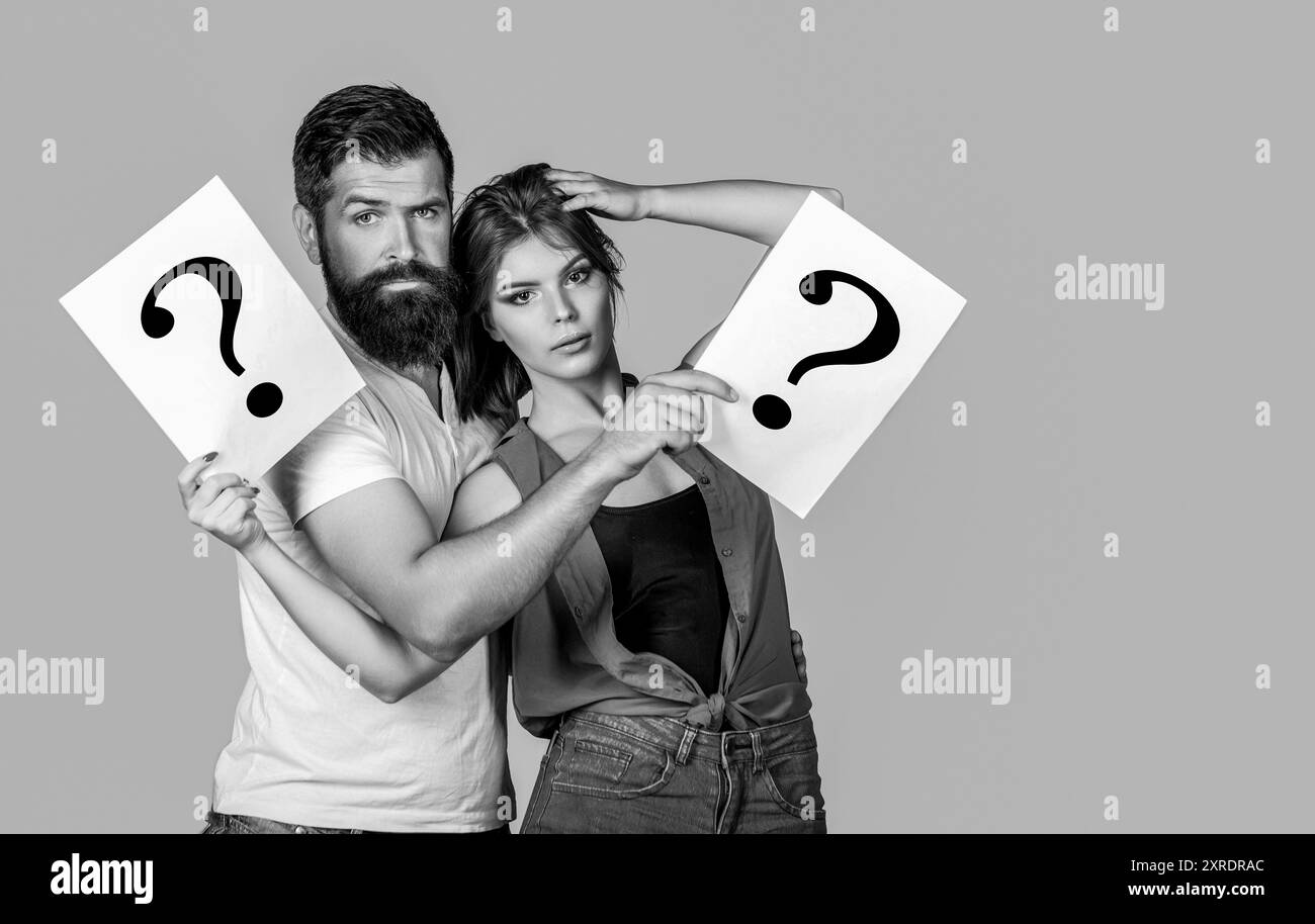 Couple holding question mark sign on gray background. Couple holding ...