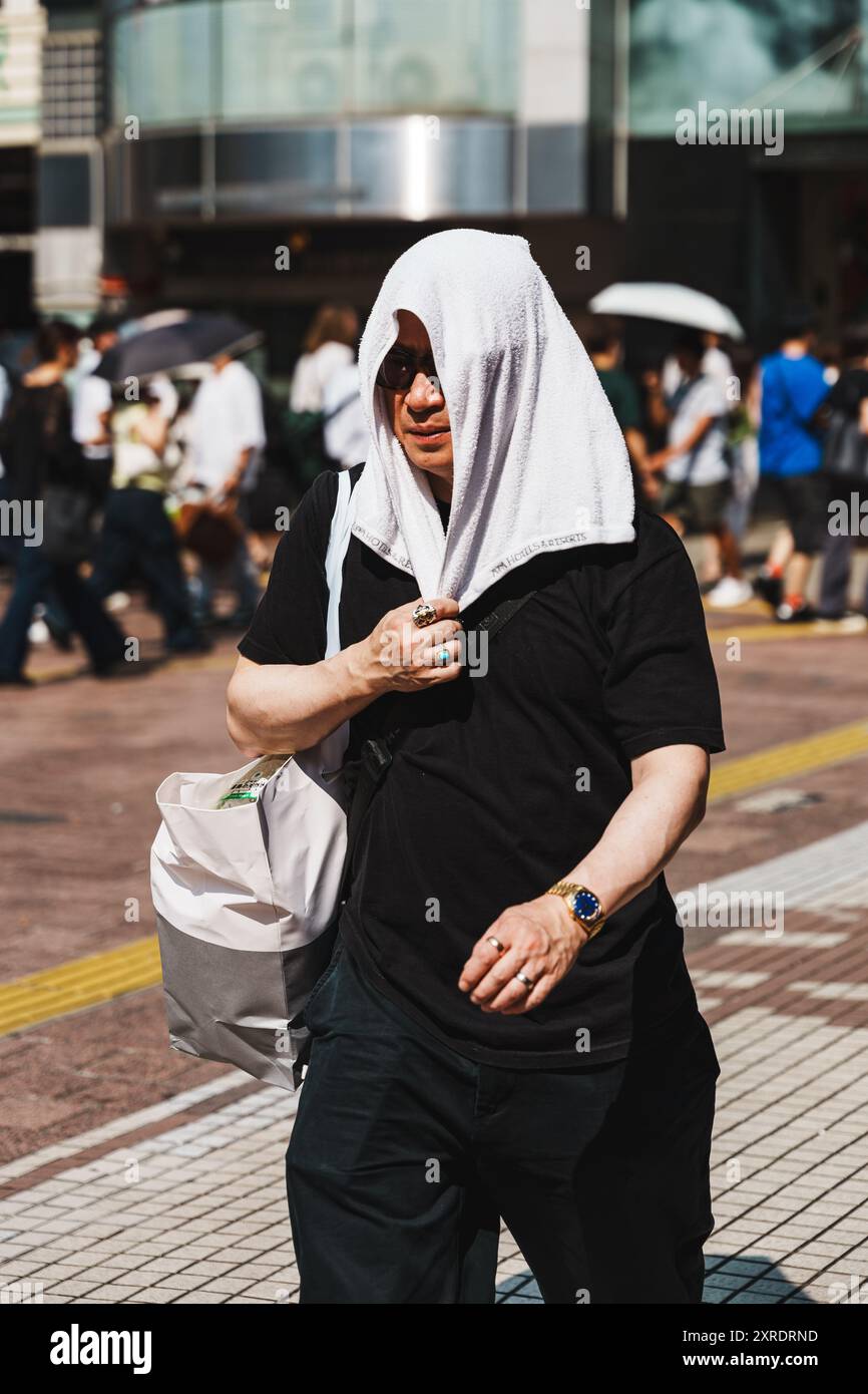 Tokyo, Japan - Aug 09, 2024: Hot Weather. Man covers his head to ...