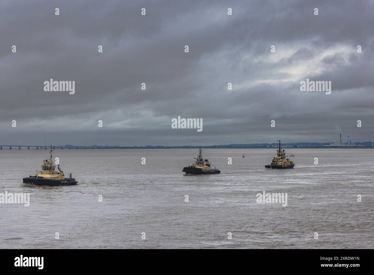 Three tugs on an overcast day Stock Photo - Alamy