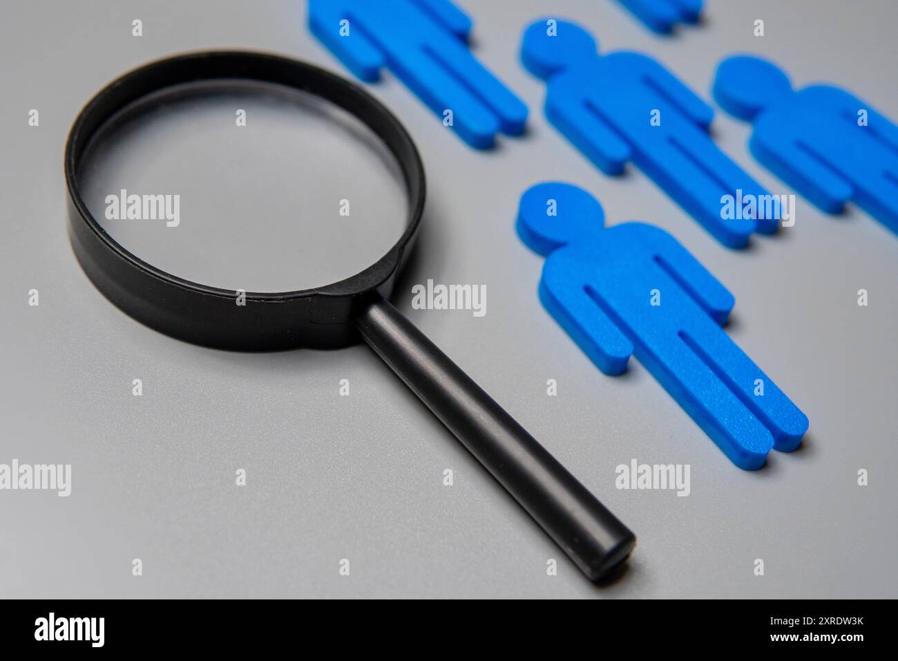 Close-up image of magnifying glass and figurines. Know your customer ...