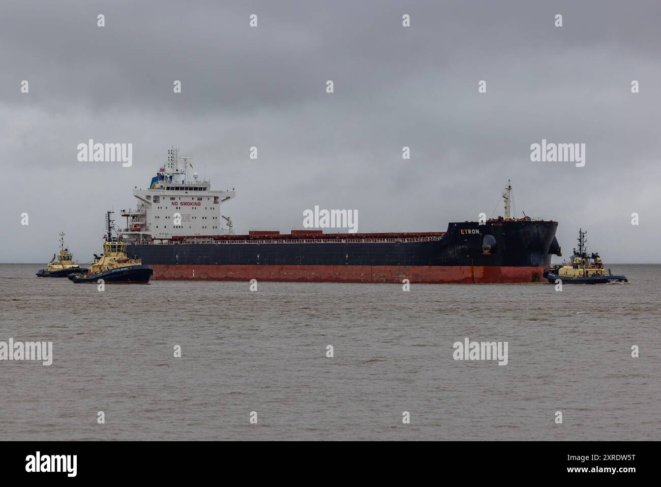 Tugs surround the bulk carrier Etron as it approaches Battery Point ...