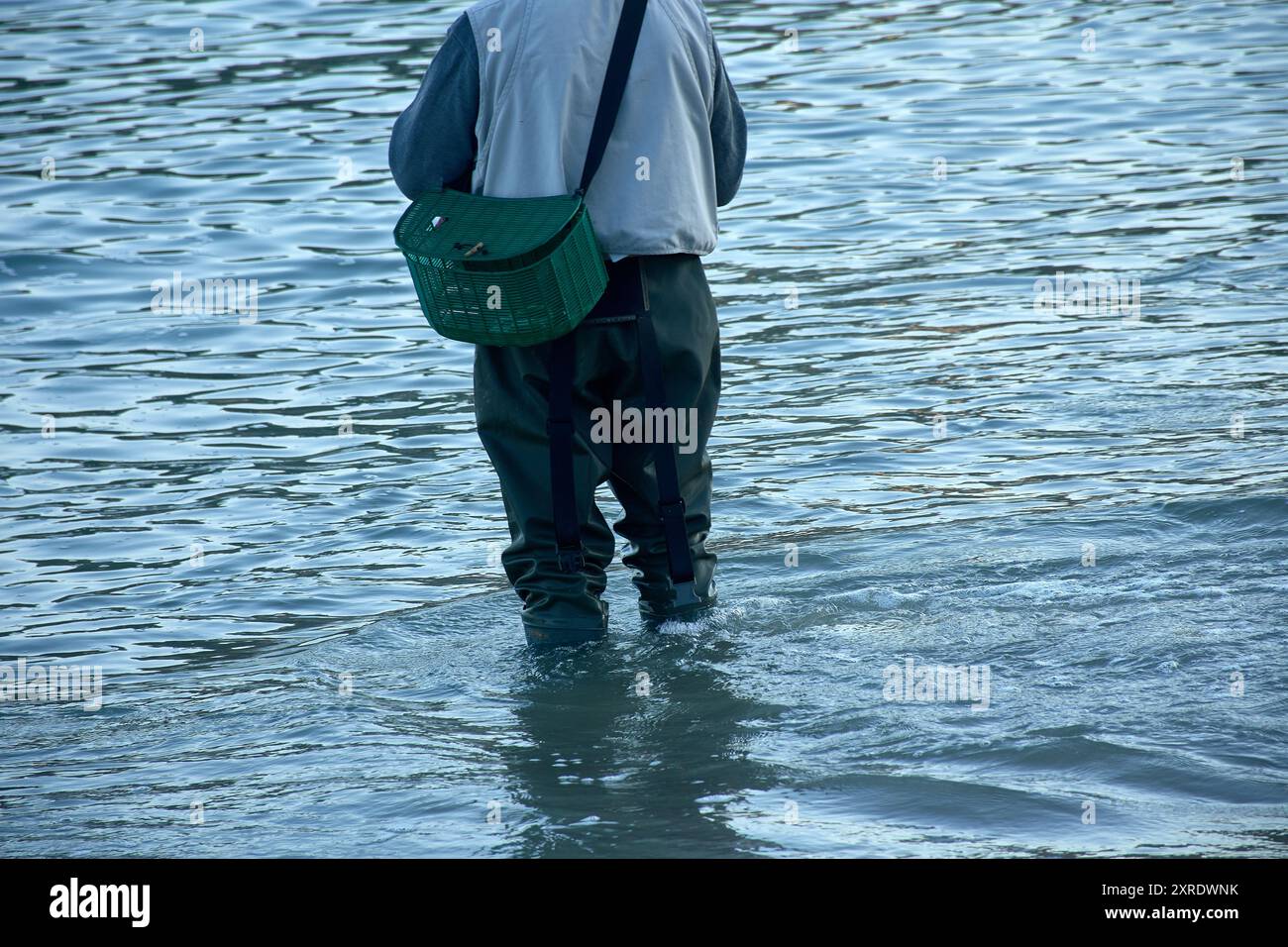 the traditional attire of a fisherman wading in the water, equipped ...