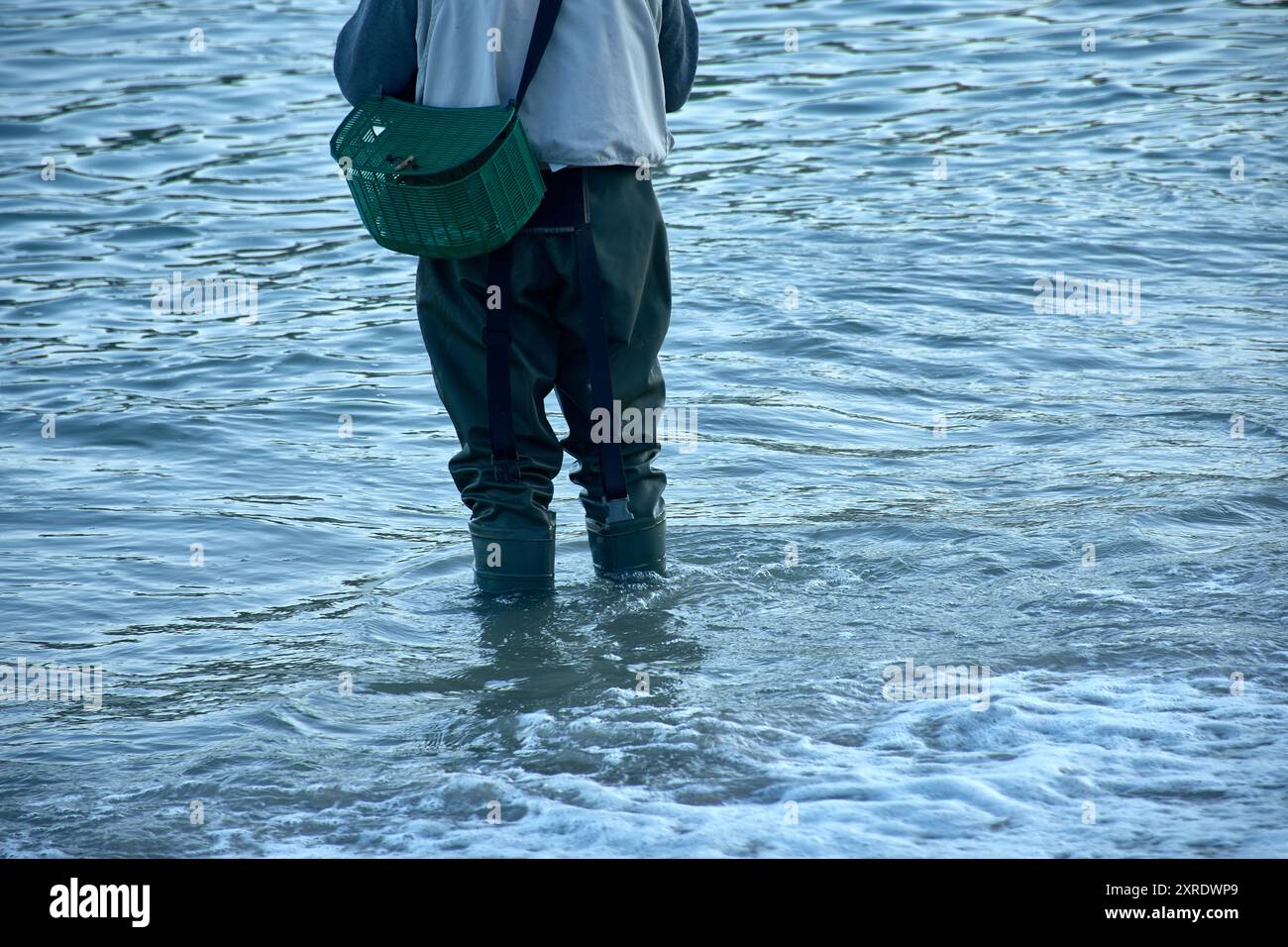 the traditional attire of a fisherman wading in the water, equipped ...