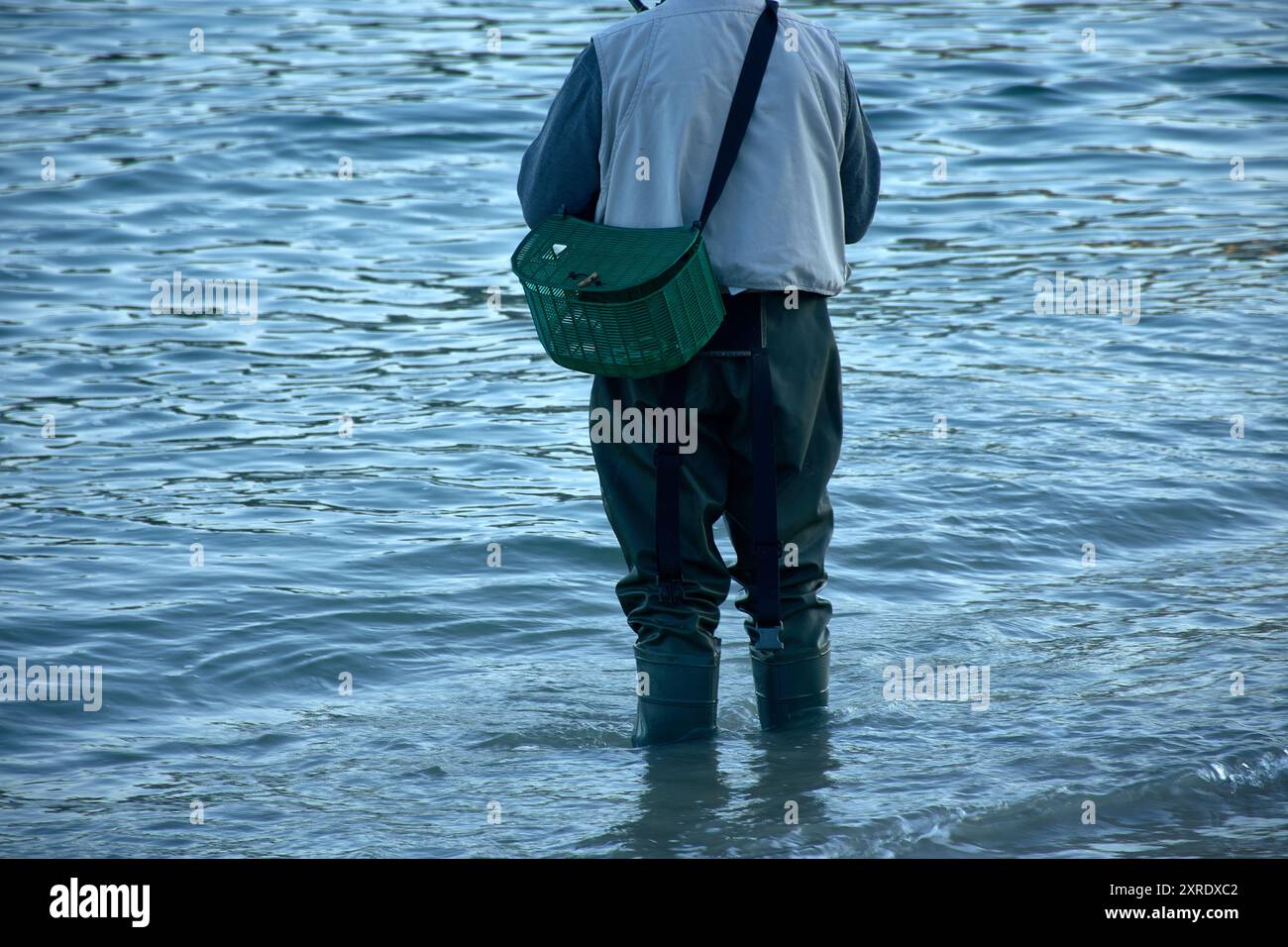 the traditional attire of a fisherman wading in the water, equipped ...