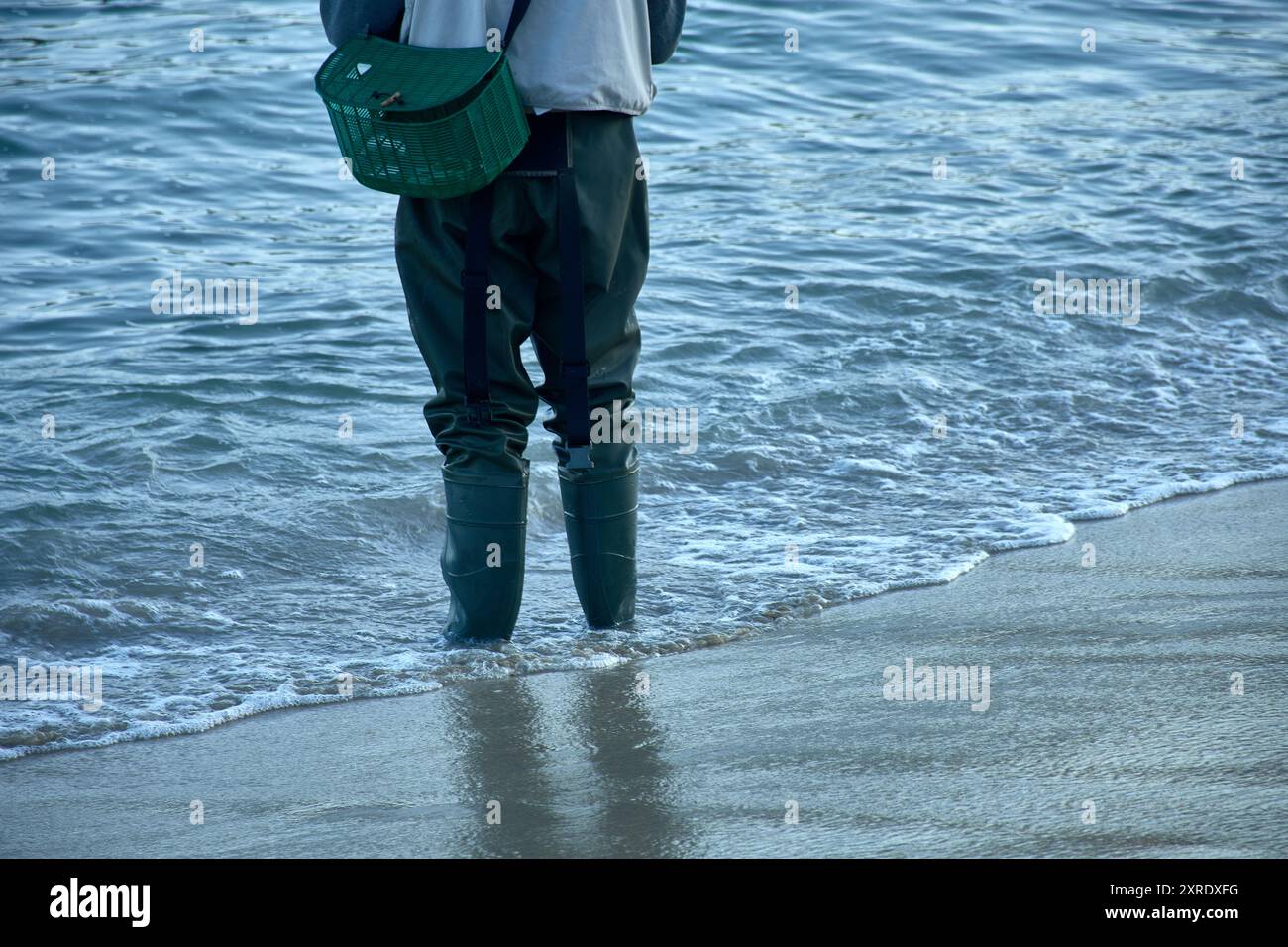 the traditional attire of a fisherman wading in the water, equipped ...