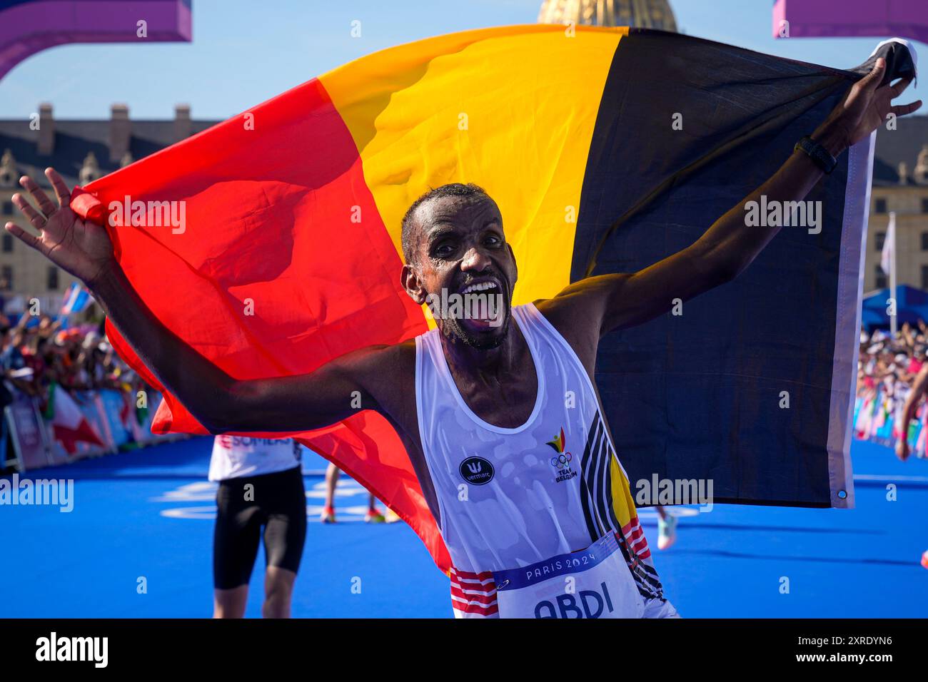 Belgium's Bashir Abdi celebrates after crossing the finish line to win ...