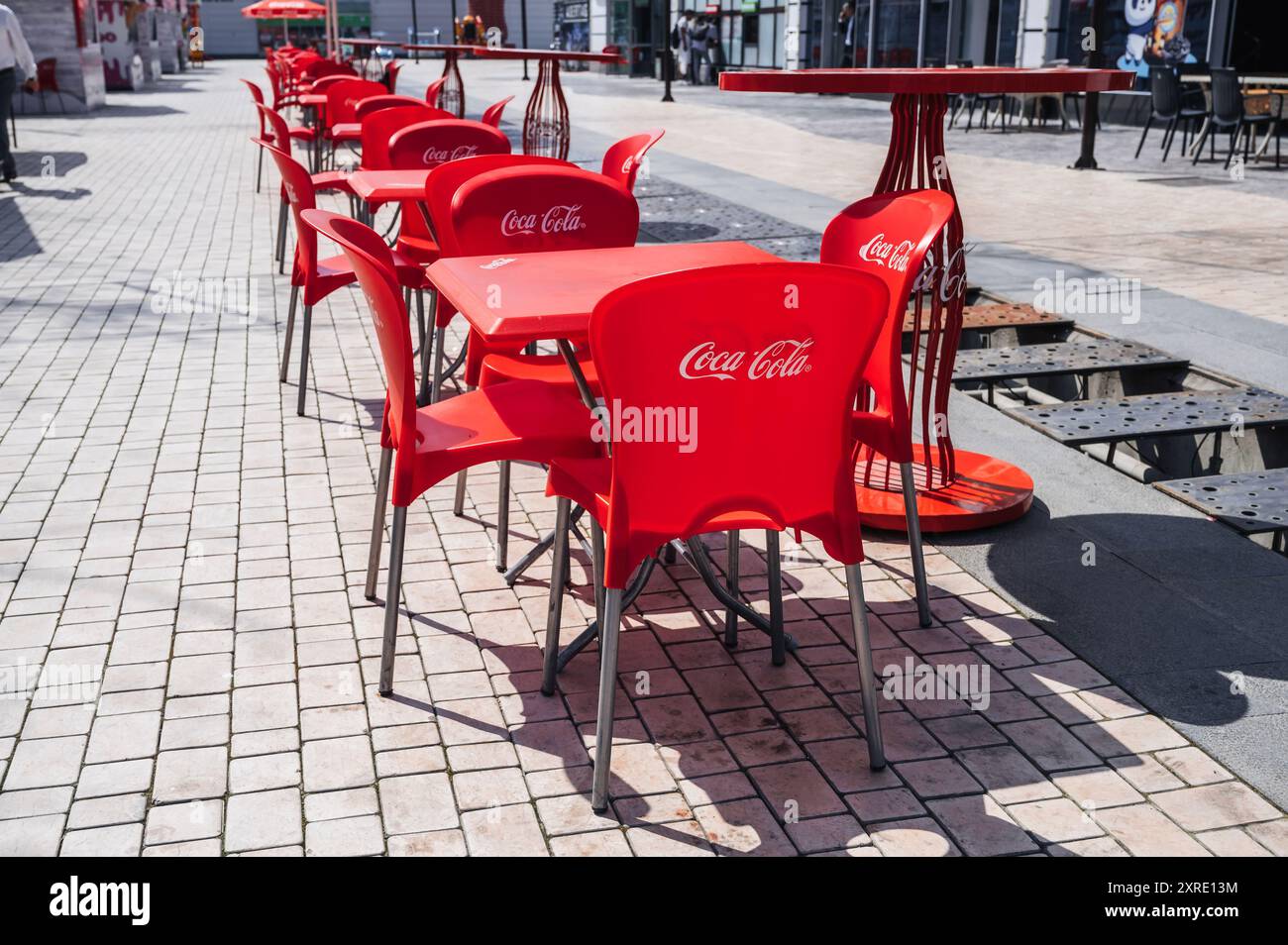 plastic red chairs and tables with Coca-Cola advertising logo in a ...