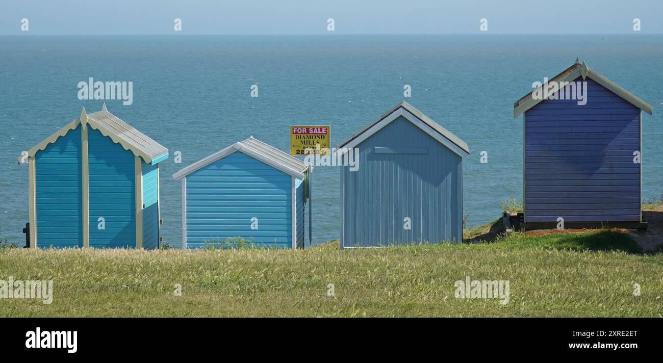 Beach huts in a row sea in background 1 hut with for sale board Stock ...