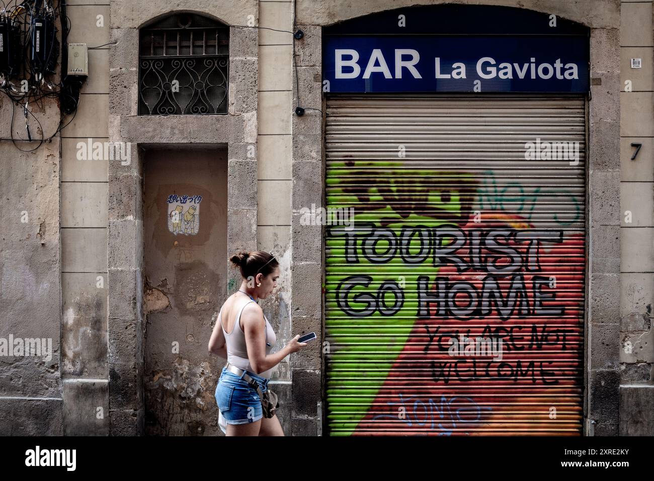 In Barcelona's Gracia neighbourhood, a woman walks past an anti-tourism ...