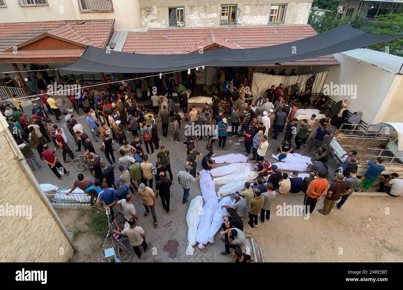 Shrouded bodies are laid down at the al-Maamadani hospital, following ...