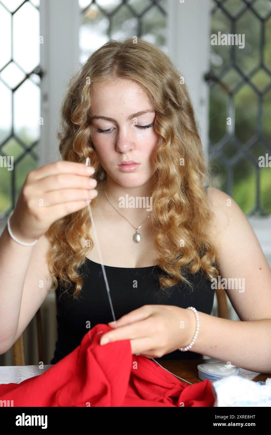 Teenage girl hand sewing with needle and thread textiles - craft skills ...