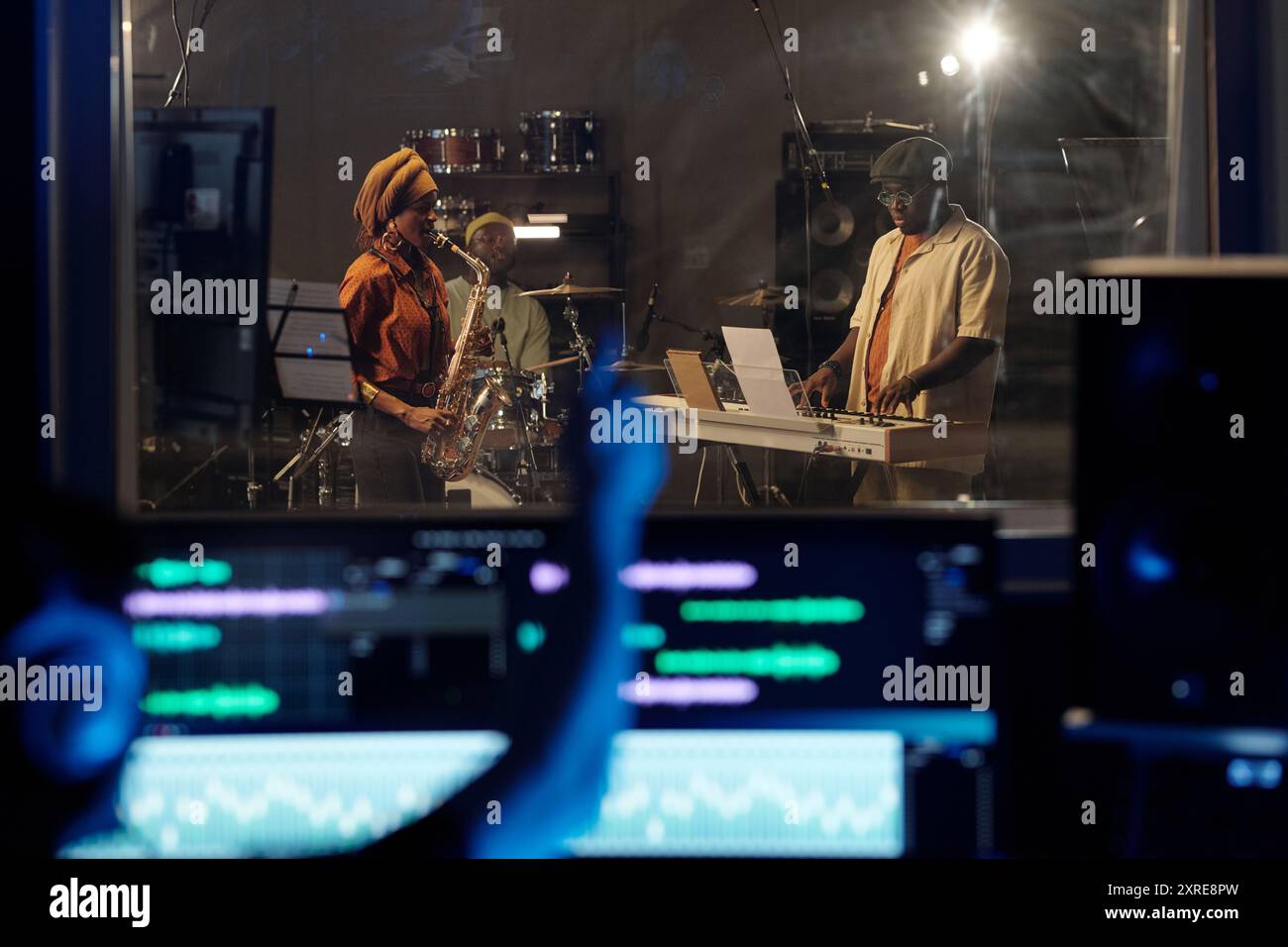 Musicians engaging in live music production in professional recording ...