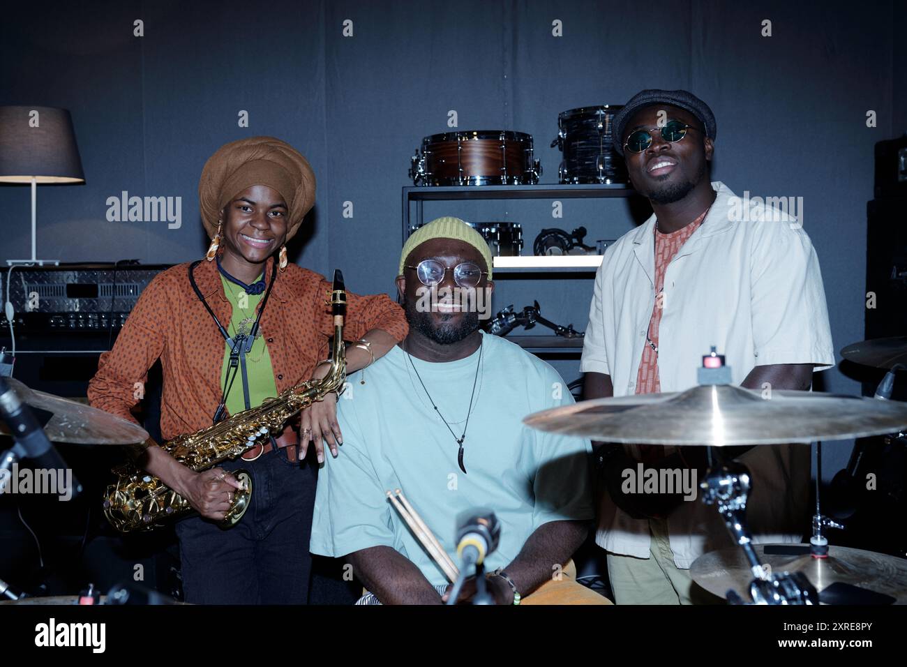 Three African American musicians smiling at camera while holding ...