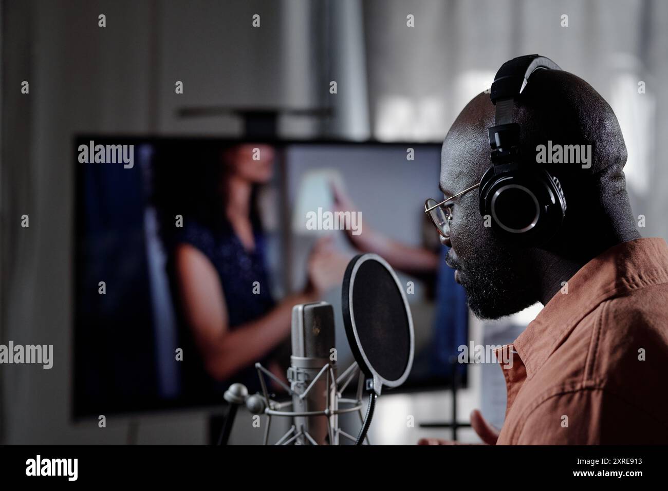 African American man using professional microphone and headphones ...